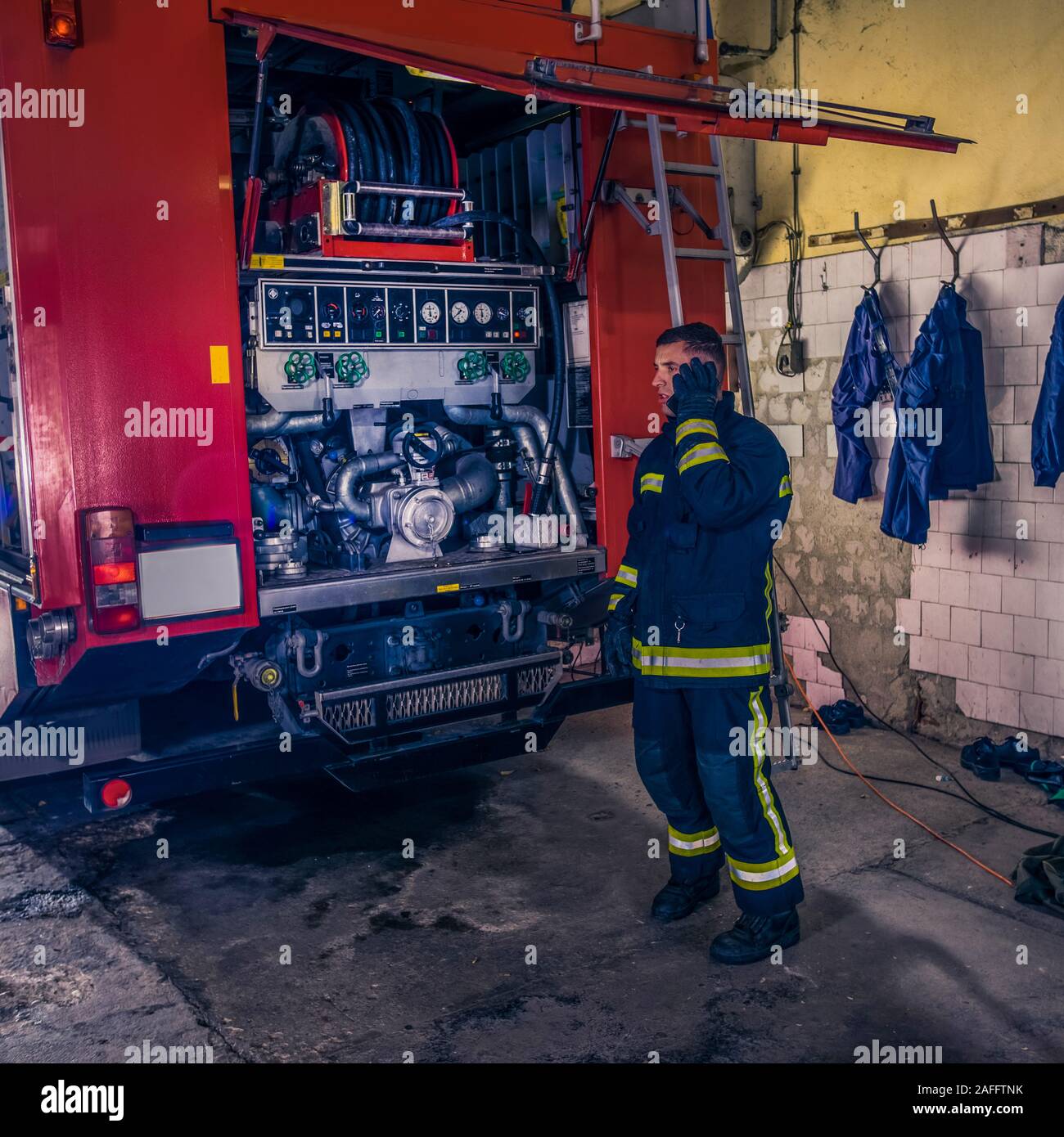 A firefighter repairing the fire engine in the fire station Stock Photo ...