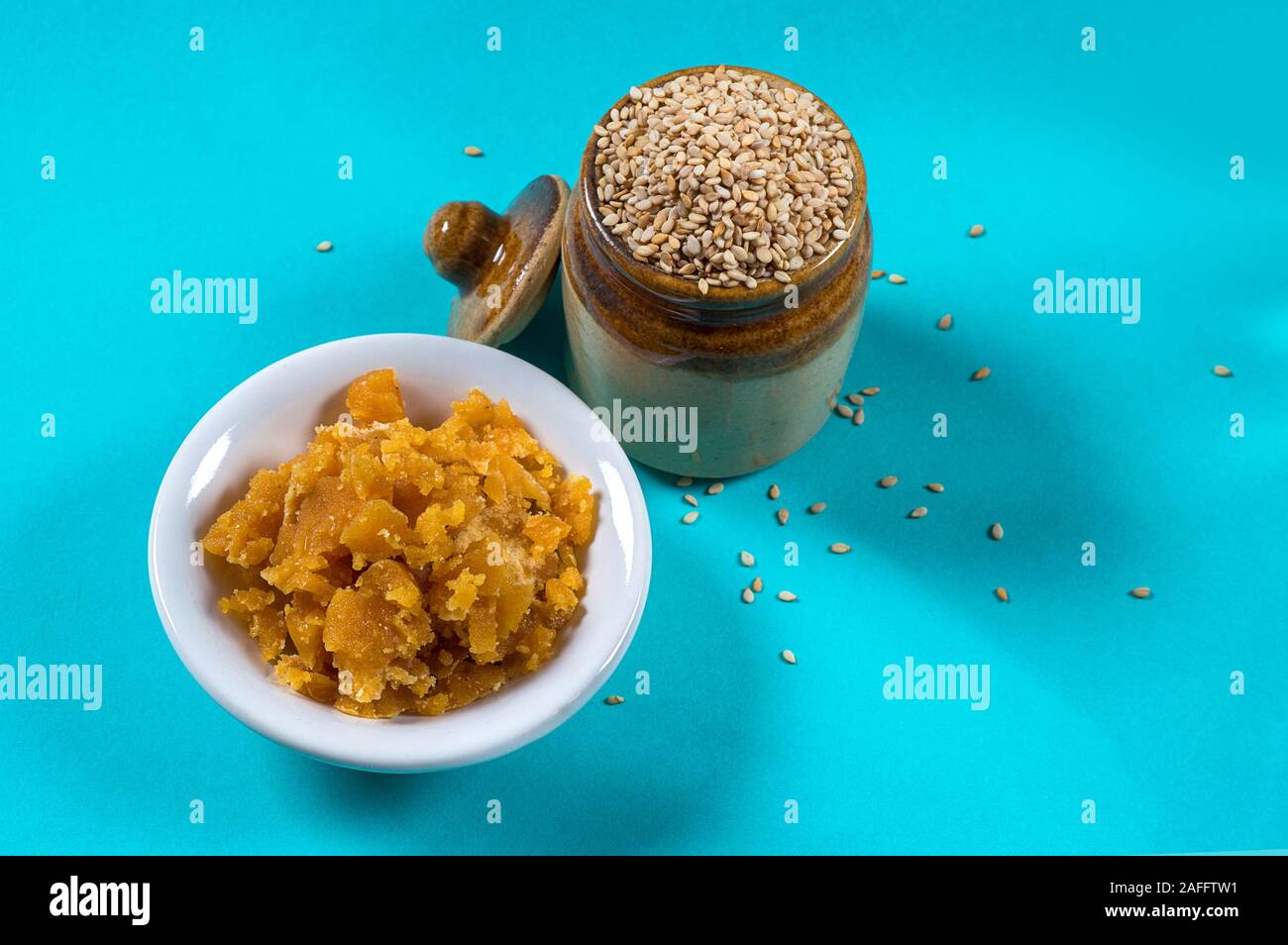 Sesame Seeds in clay pot with Jaggery in bowl on blue background Stock ...