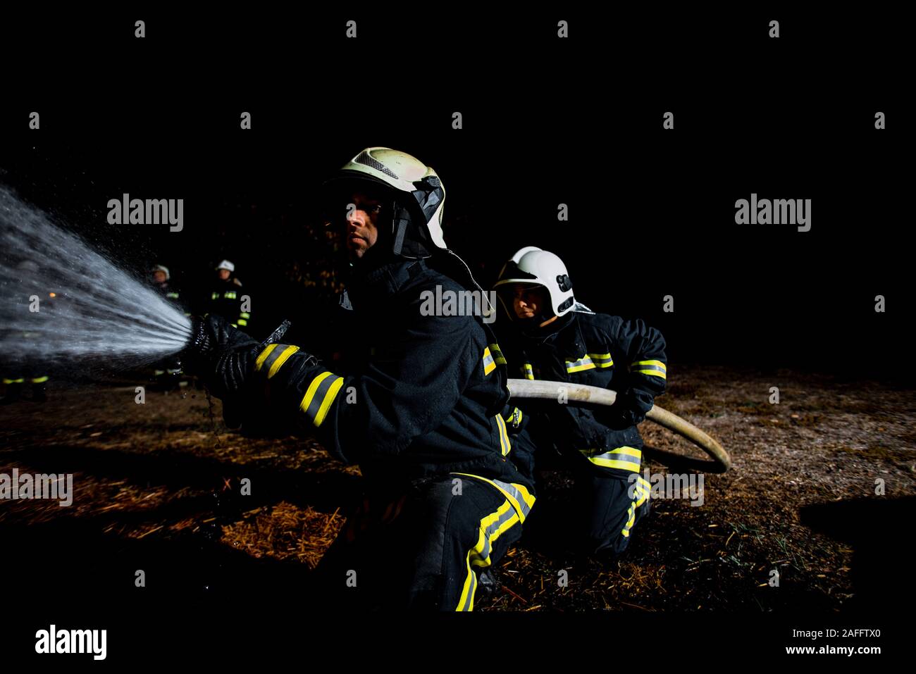 Firemen wearing protective gear during a firefighting intervention ...