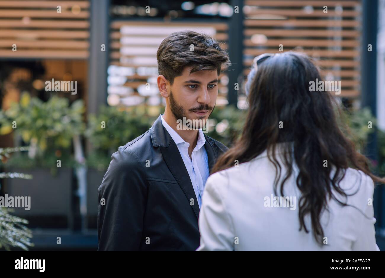 Positive team members discussing project during outdoor break. Two ...