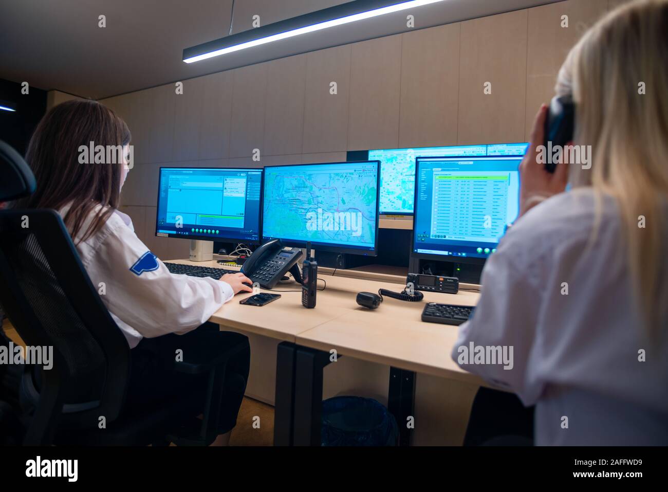 Female security guards working on computers while sitting in the main ...