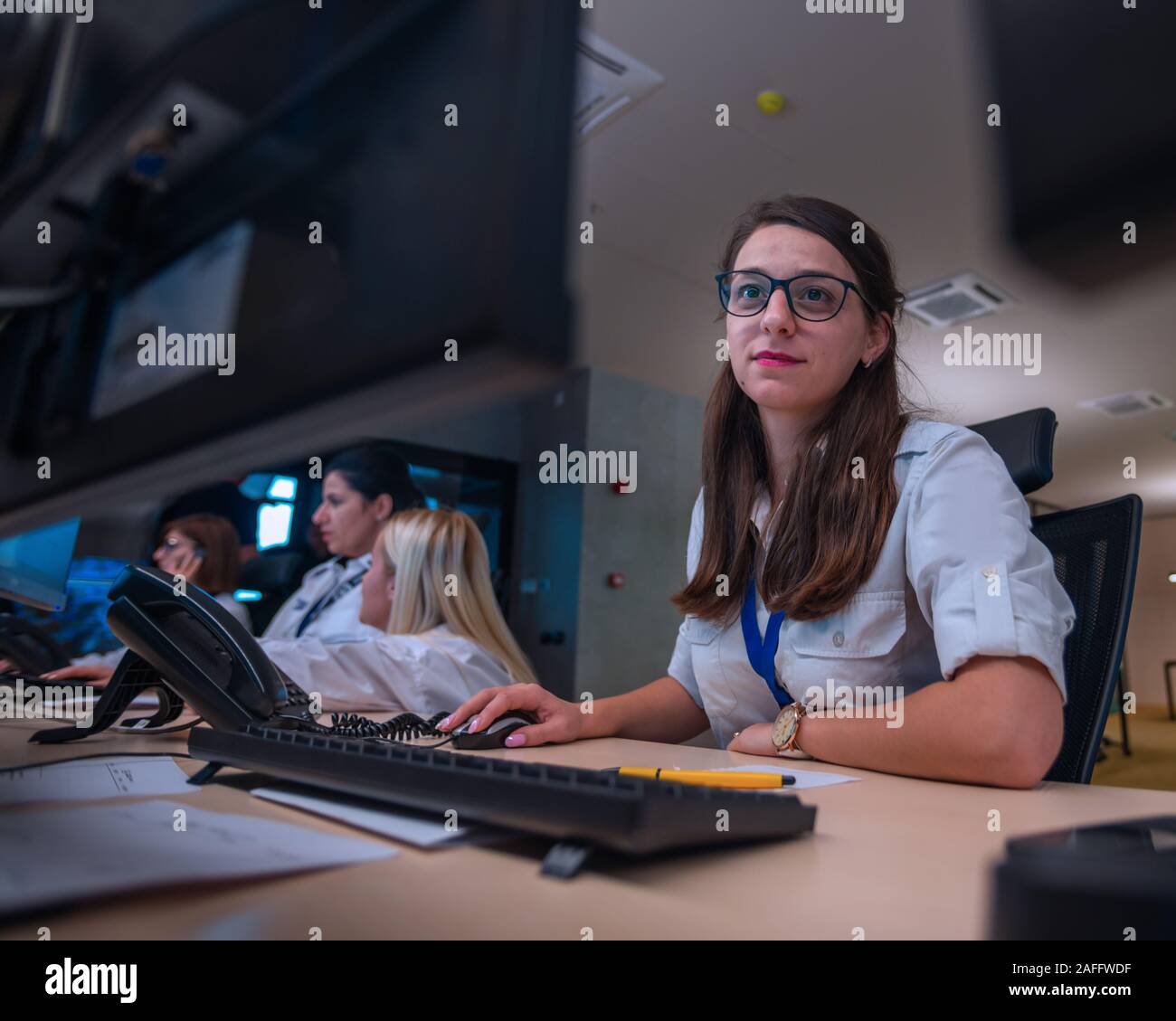 Female security guards working on computers while sitting in the main ...