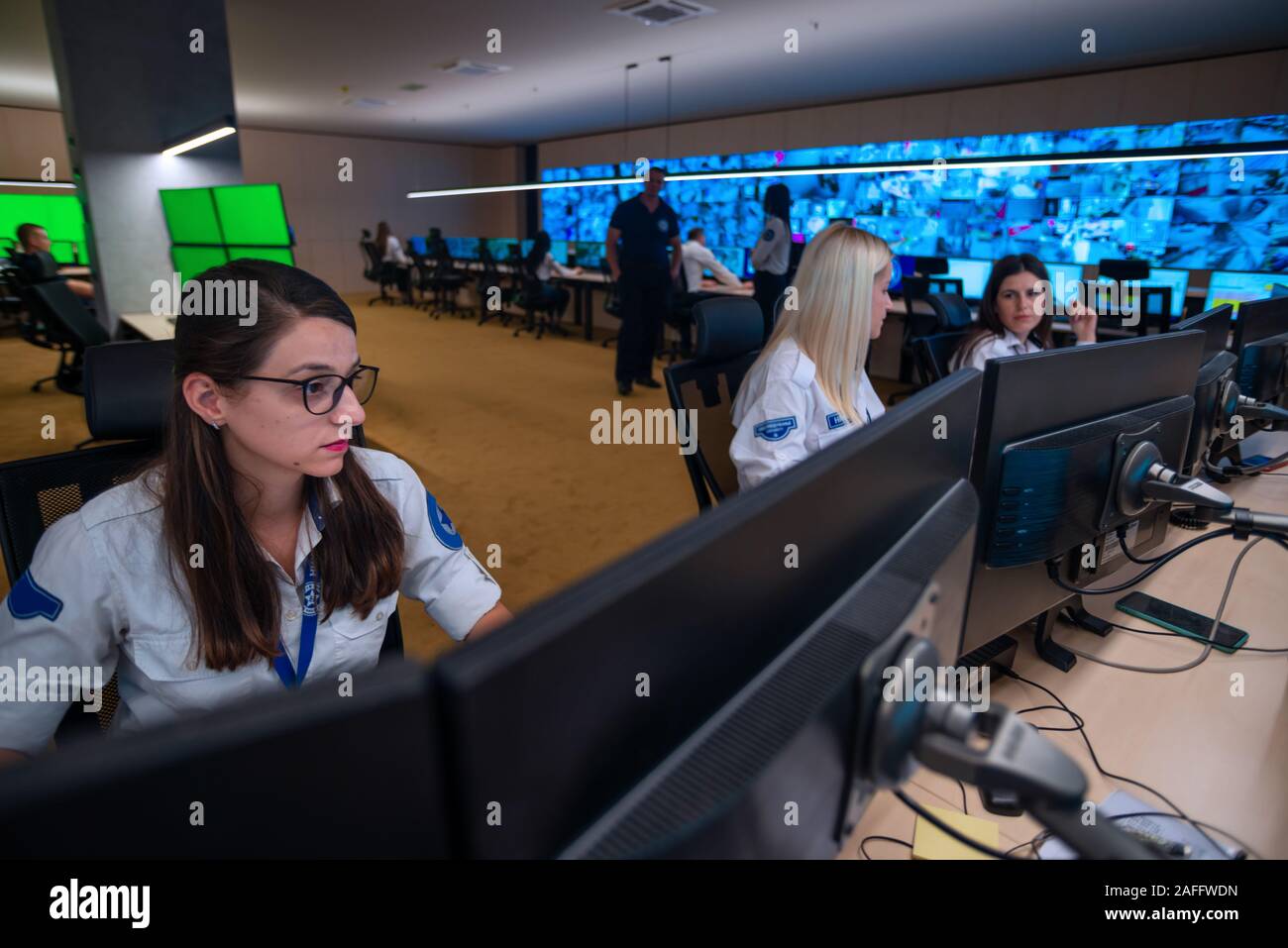 Female security guards working on computers while sitting in the main ...
