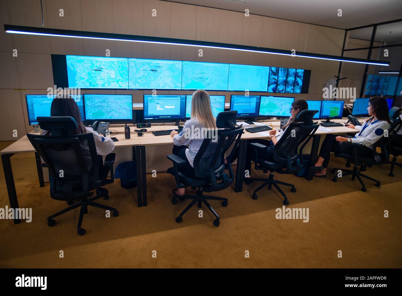 Female security guards working on computers while sitting in the main ...