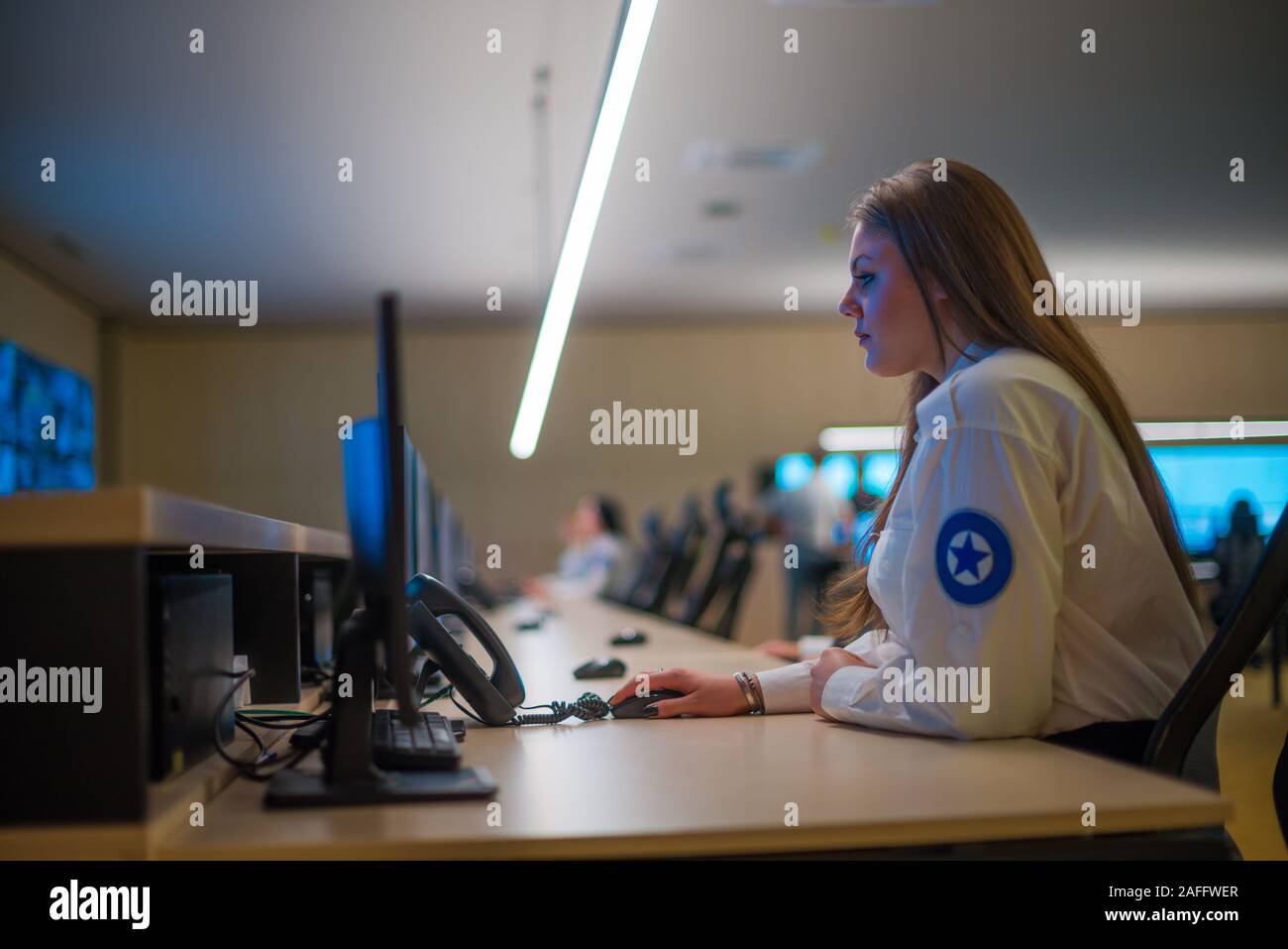 Female security guard sitting and monitoring modern CCTV cameras in a ...