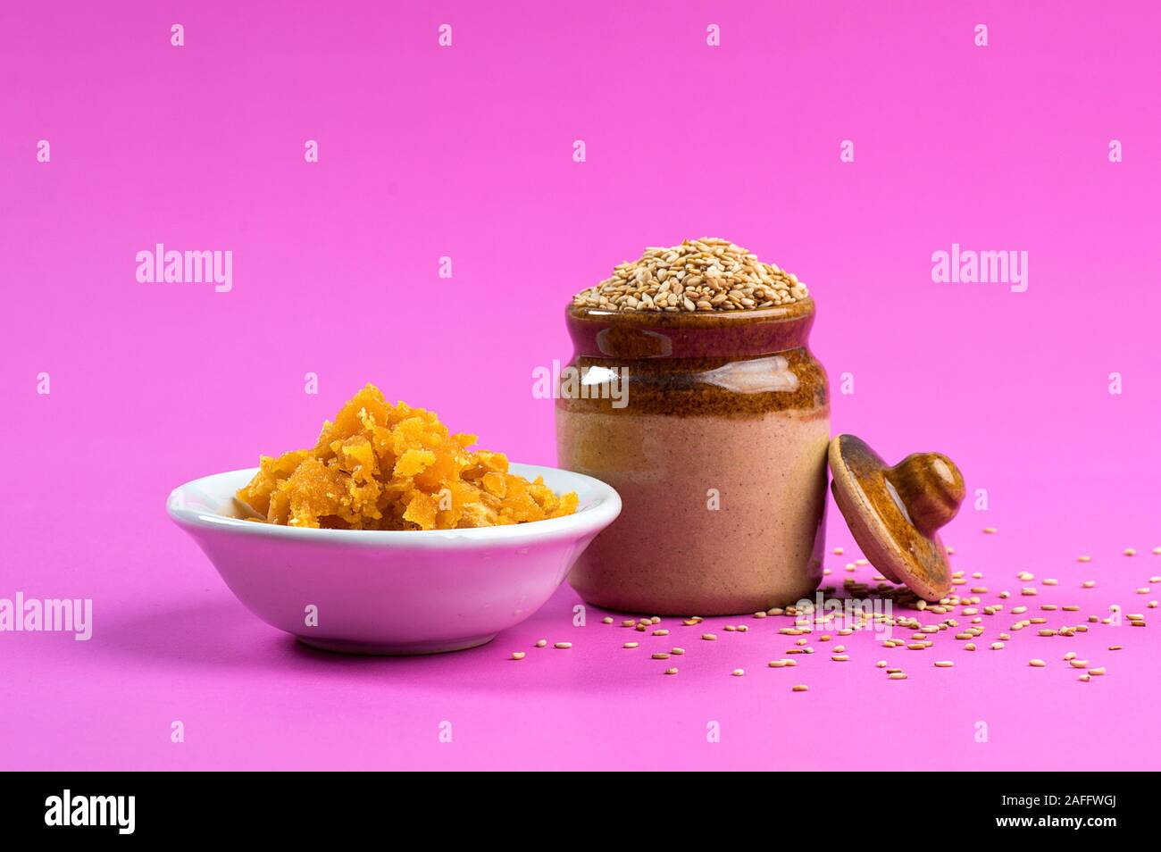 Sesame Seeds in clay pot with Jaggery in bowl on pink background Stock ...
