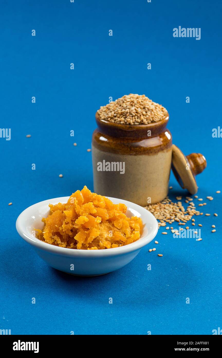 Sesame Seeds in clay pot with Jaggery in bowl on blue background Stock ...