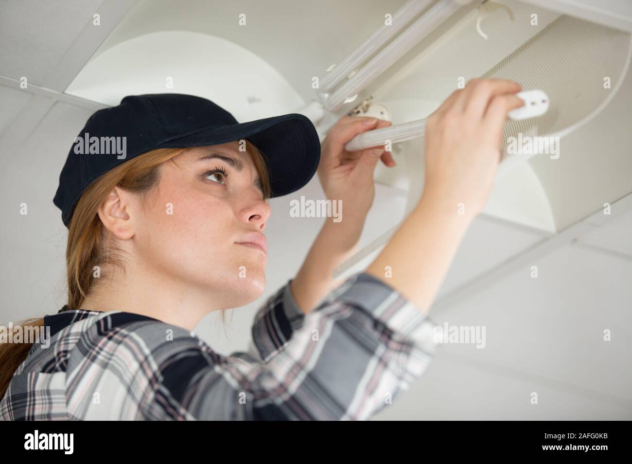 Woman replacing light bulb hi-res stock photography and images - Alamy