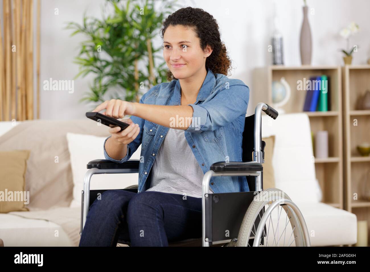 disabled woman watching tv in the living room Stock Photo - Alamy