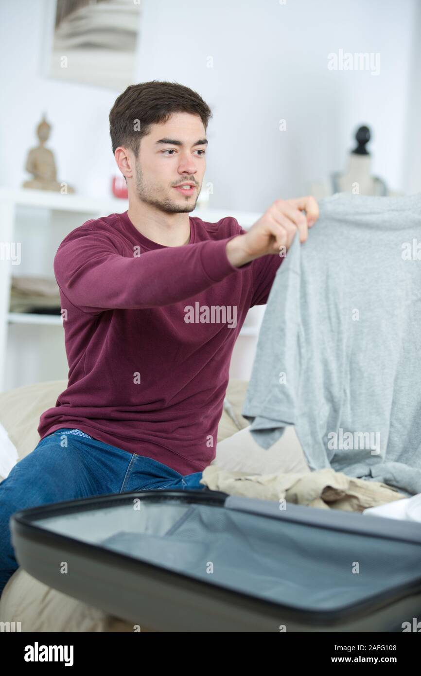 young man packing a suitcase Stock Photo - Alamy