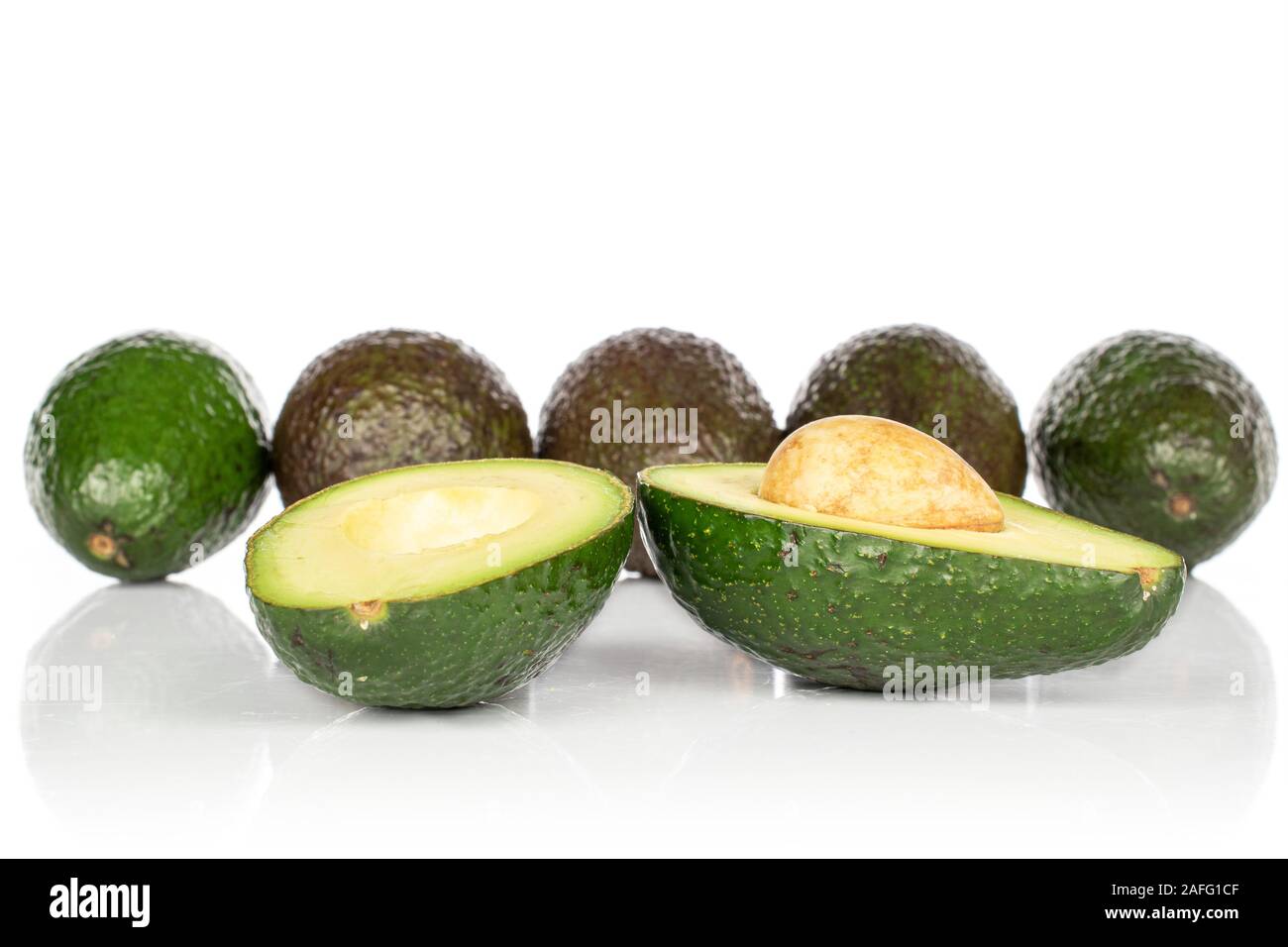 Group of five whole two halves of fresh green avocado isolated on white ...