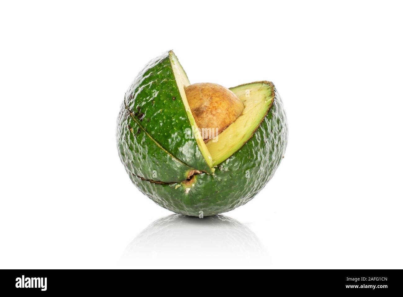 One whole fresh green avocado with cut quarter isolated on white ...