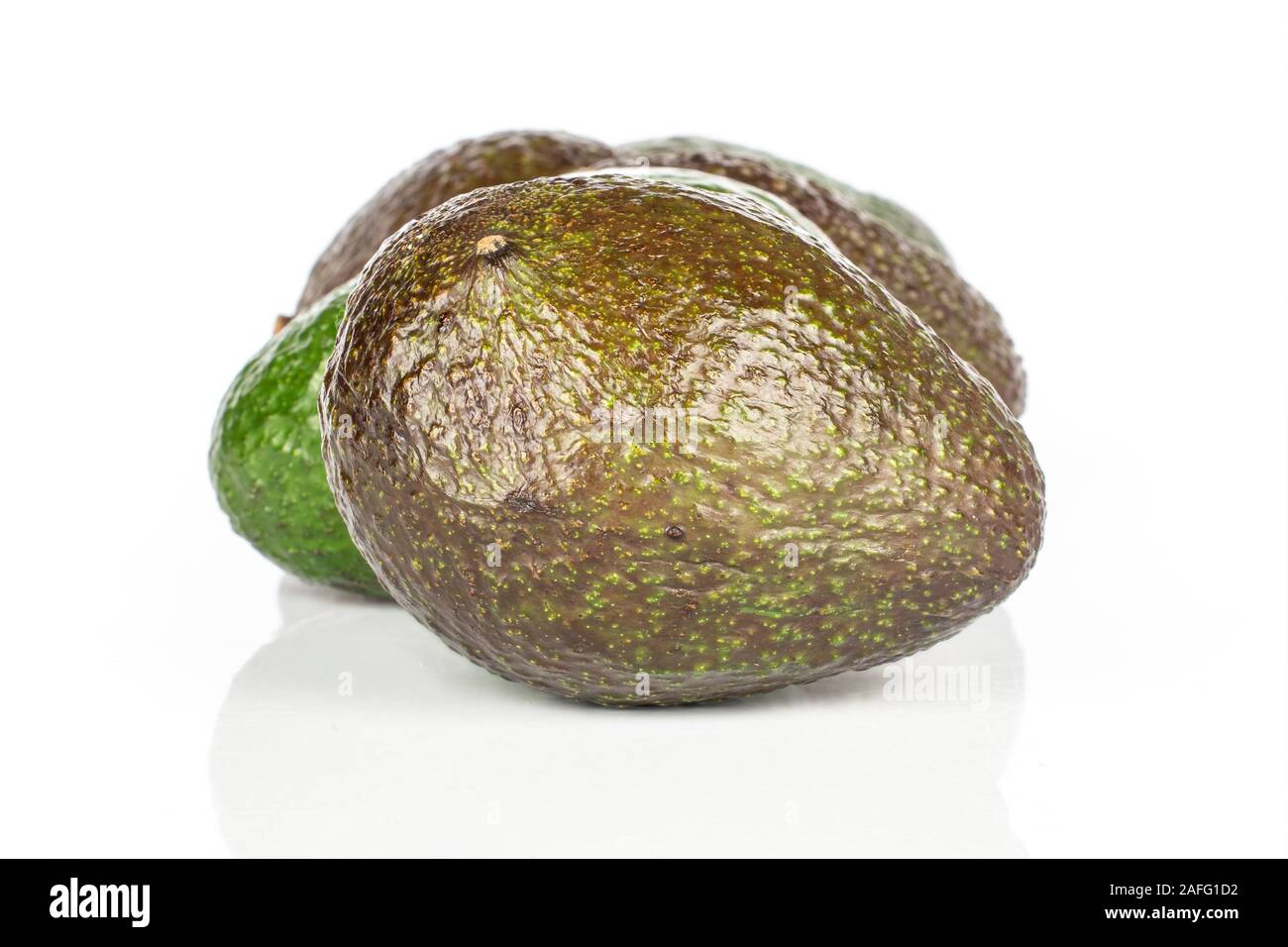 Group of four whole fresh green avocado front focus isolated on white ...