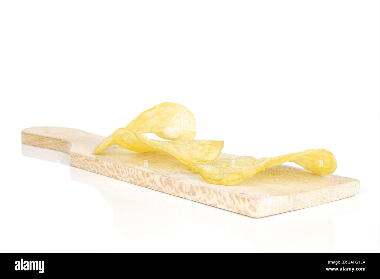 Group of three whole crisp potato chip on wooden cutting board isolated ...