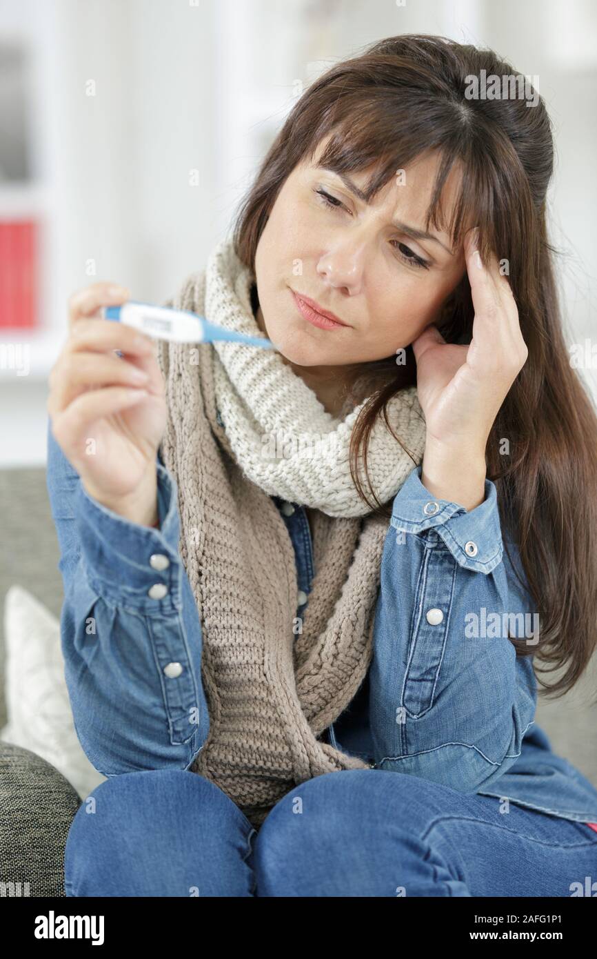 woman with temperature looking at thermometer Stock Photo - Alamy