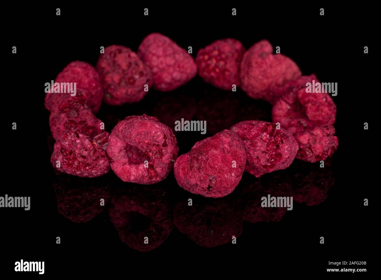 Lot of whole dried raspberry circle isolated on black glass Stock Photo ...