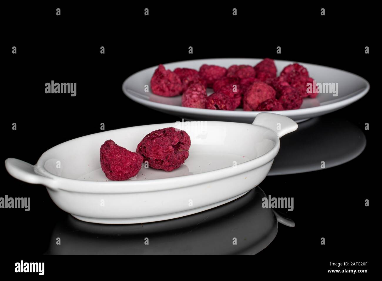 Lot of whole bright dried raspberry on white ceramic plate isolated on ...