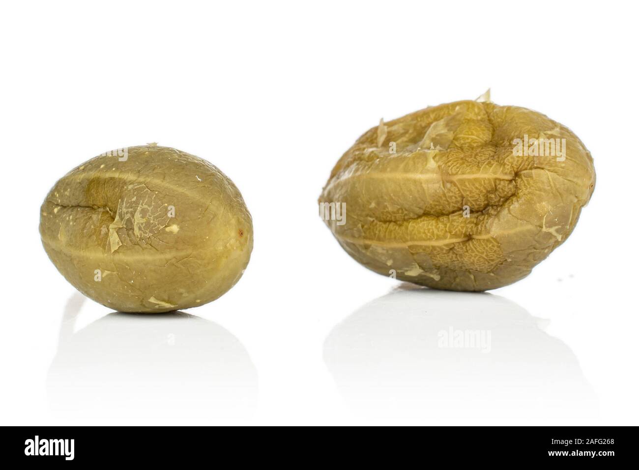 Group of two whole pickled green caper isolated on white background ...