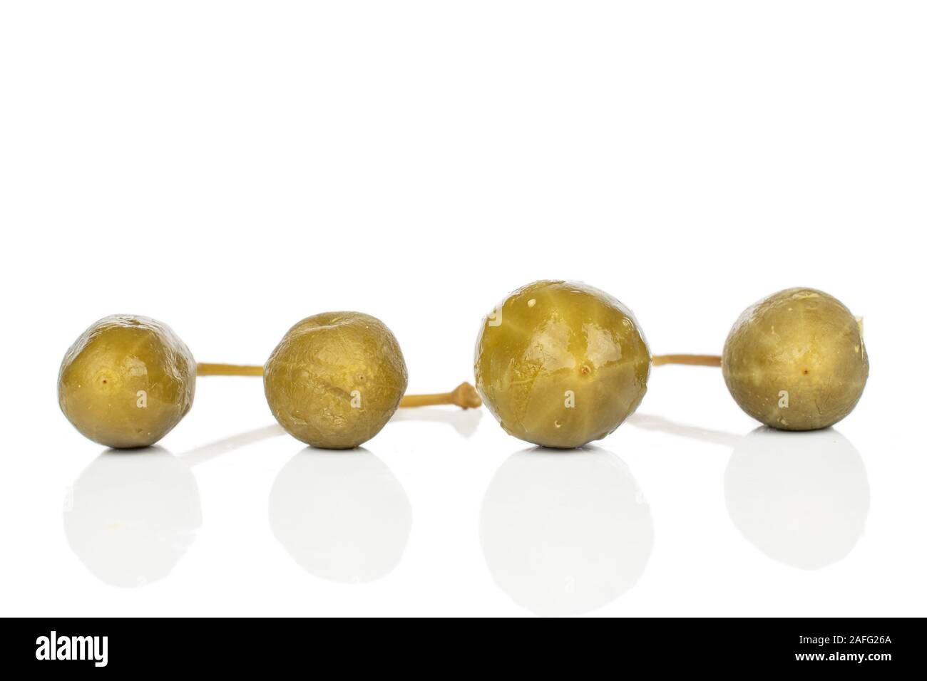 Group of four whole pickled green caper isolated on white background ...
