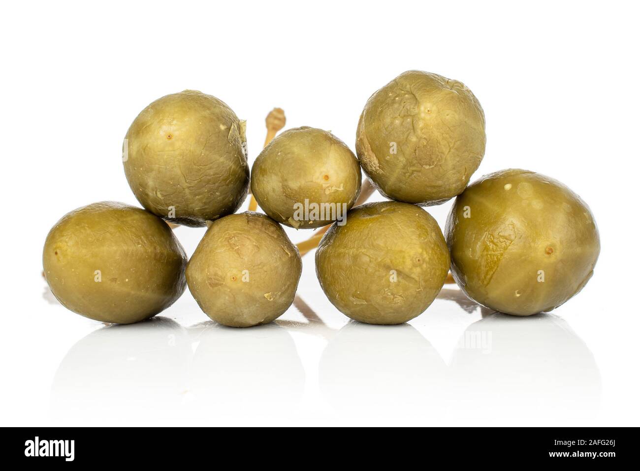 Group of seven whole pickled green caper isolated on white background ...