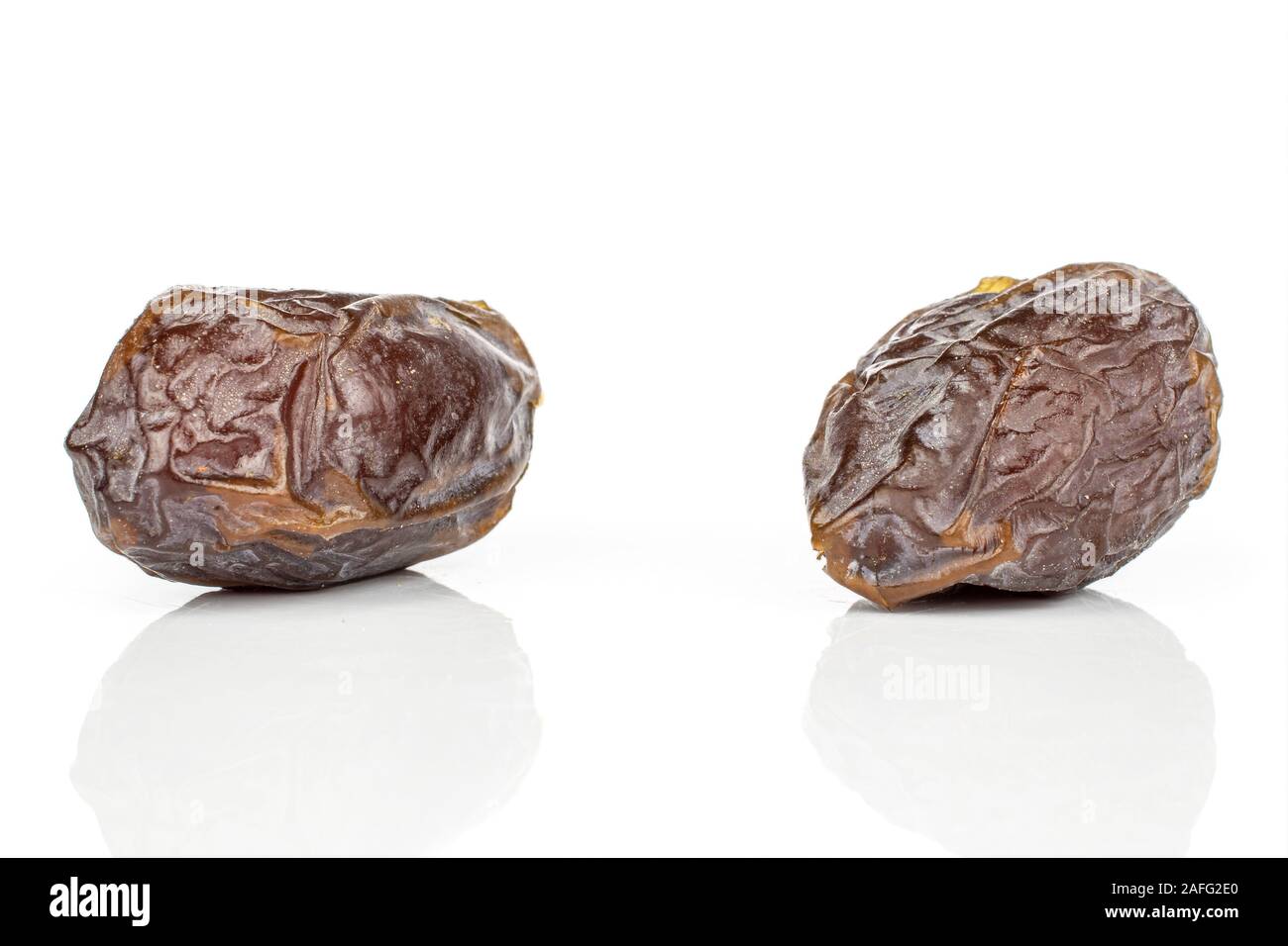 Group of two whole dried brown date fruit isolated on white background ...