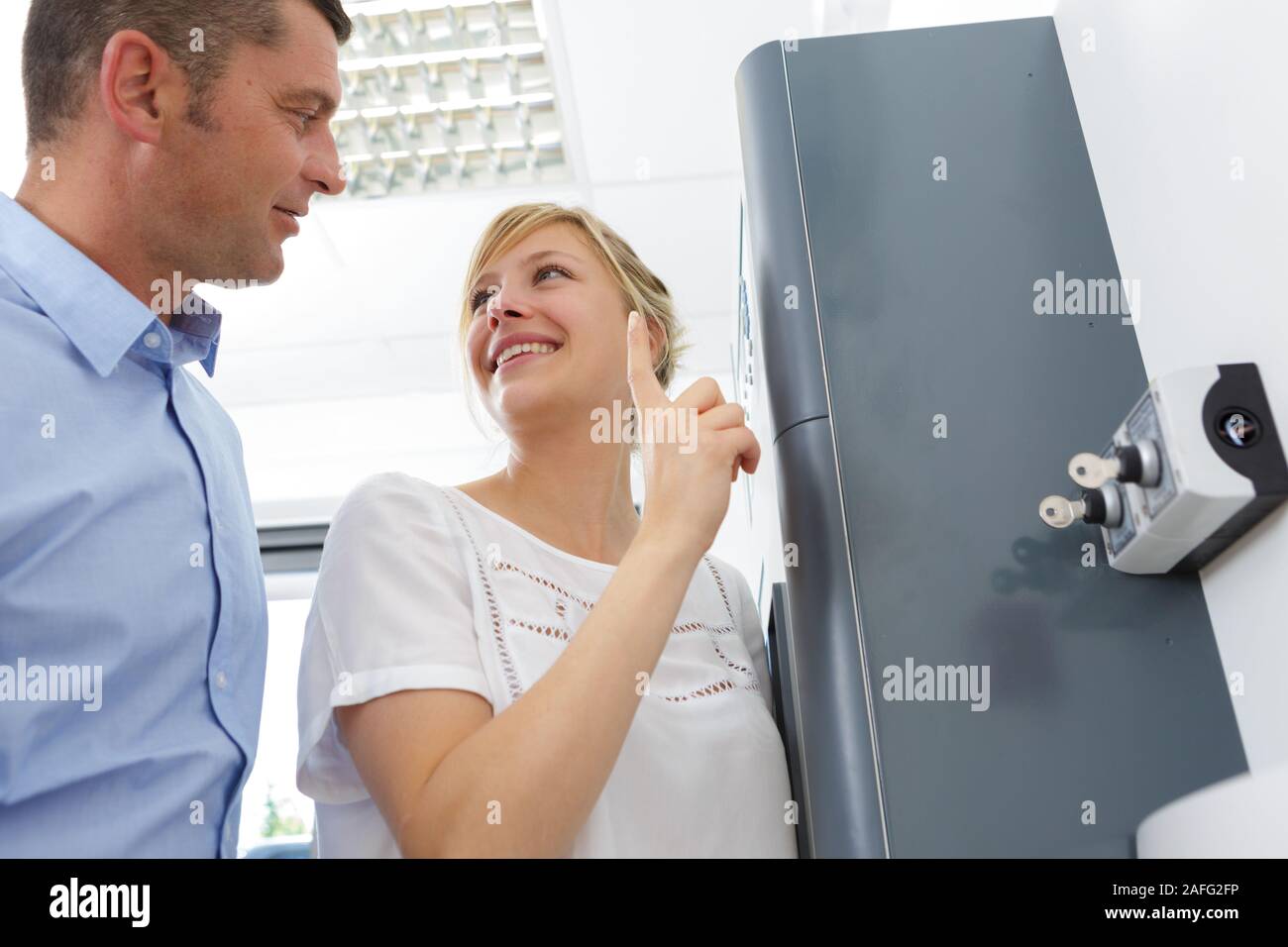 woman showing keys in control switches to male colleague Stock Photo ...