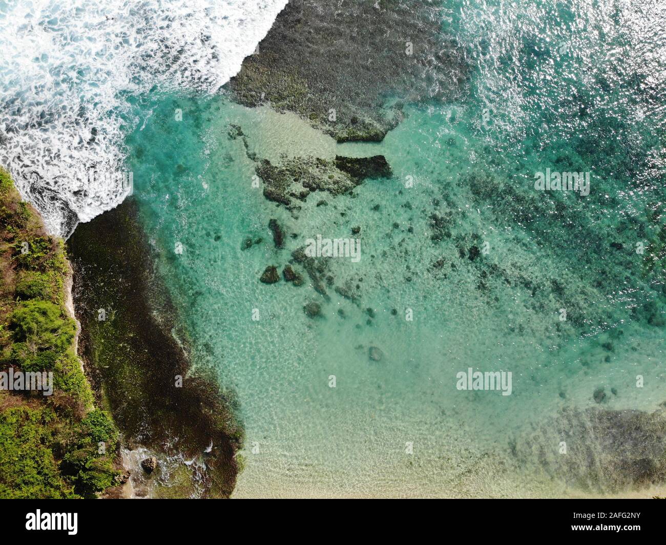 Aerial view of an amazing little beach with rock cliff in Bali ...