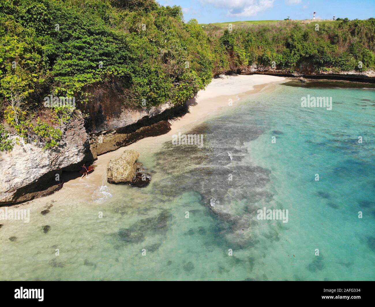 Aerial view of an amazing little beach with rock cliff in Bali ...