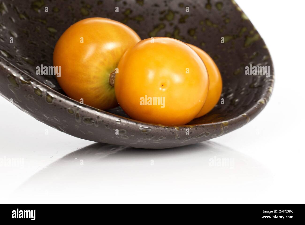 Group of three whole fresh orange physalis in glazed bowl isolated on ...