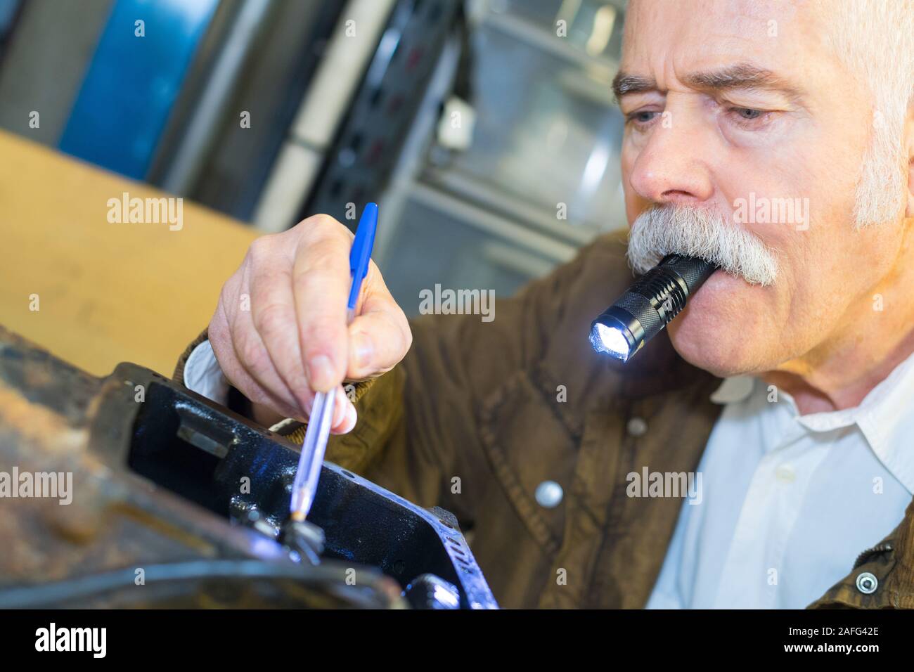 mechanic holding torch in mouth Stock Photo - Alamy