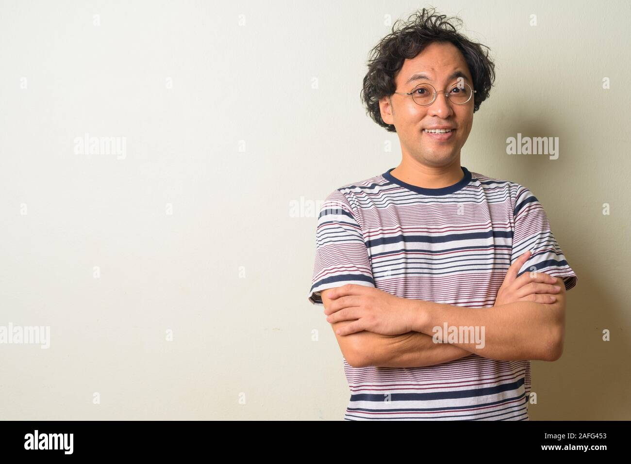 Portrait of happy Japanese man smiling with arms crossed Stock Photo ...