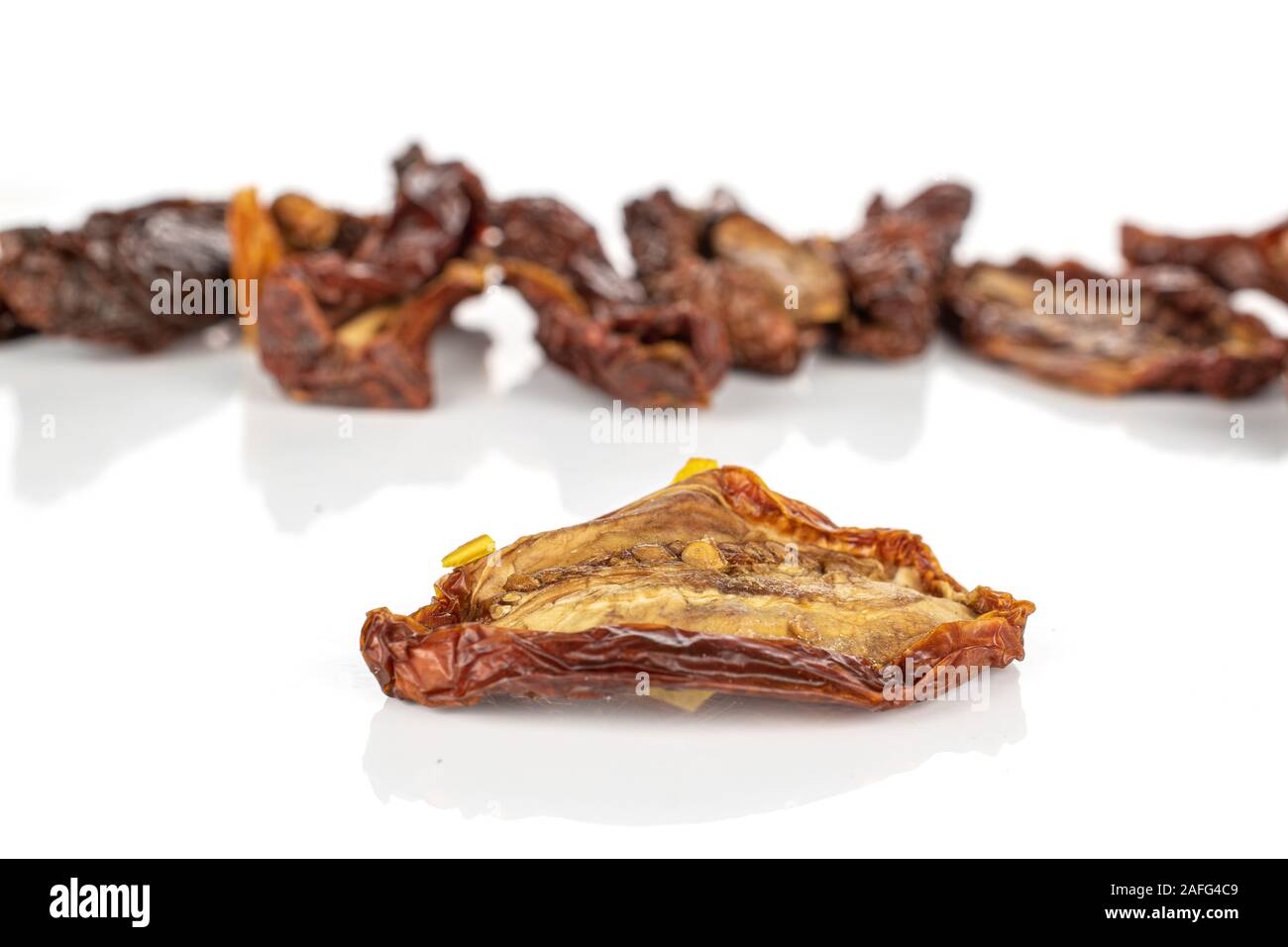 Group of eight whole dried red tomato piece isolated on white ...