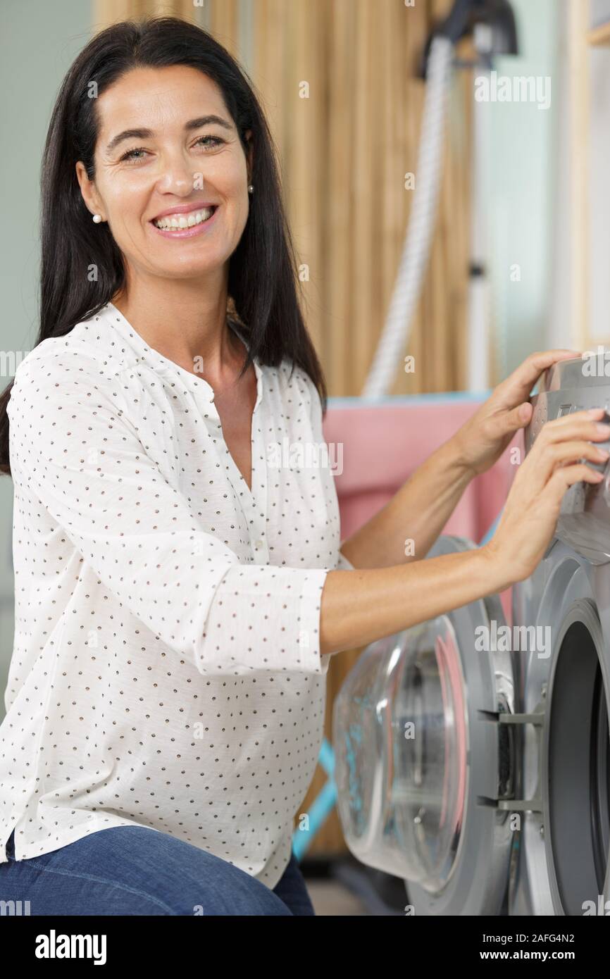 happy housewife woman in laundry room with washing machine Stock Photo ...