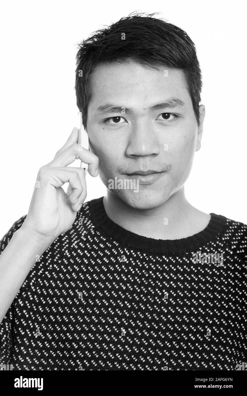 Face of young Asian man talking on mobile phone Stock Photo - Alamy