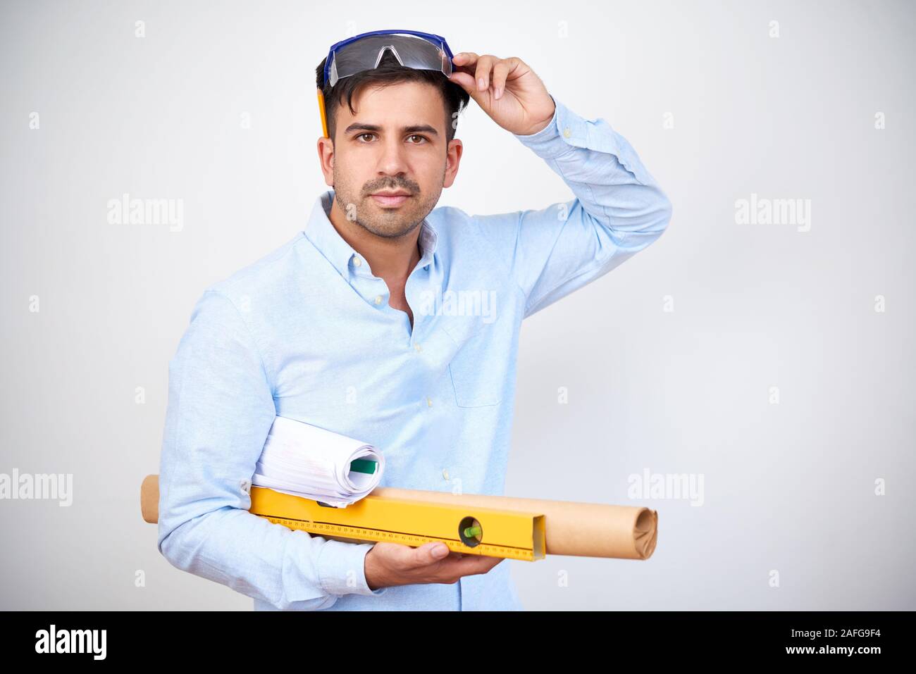 Head engineer with construction level and blueprint taking off goggles ...