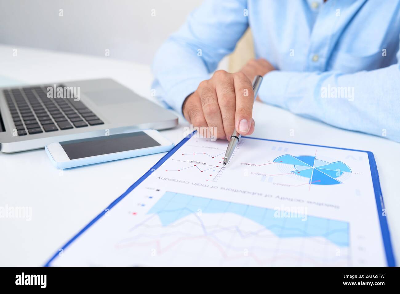 Financial manager pointing at chart with financial data in annual ...