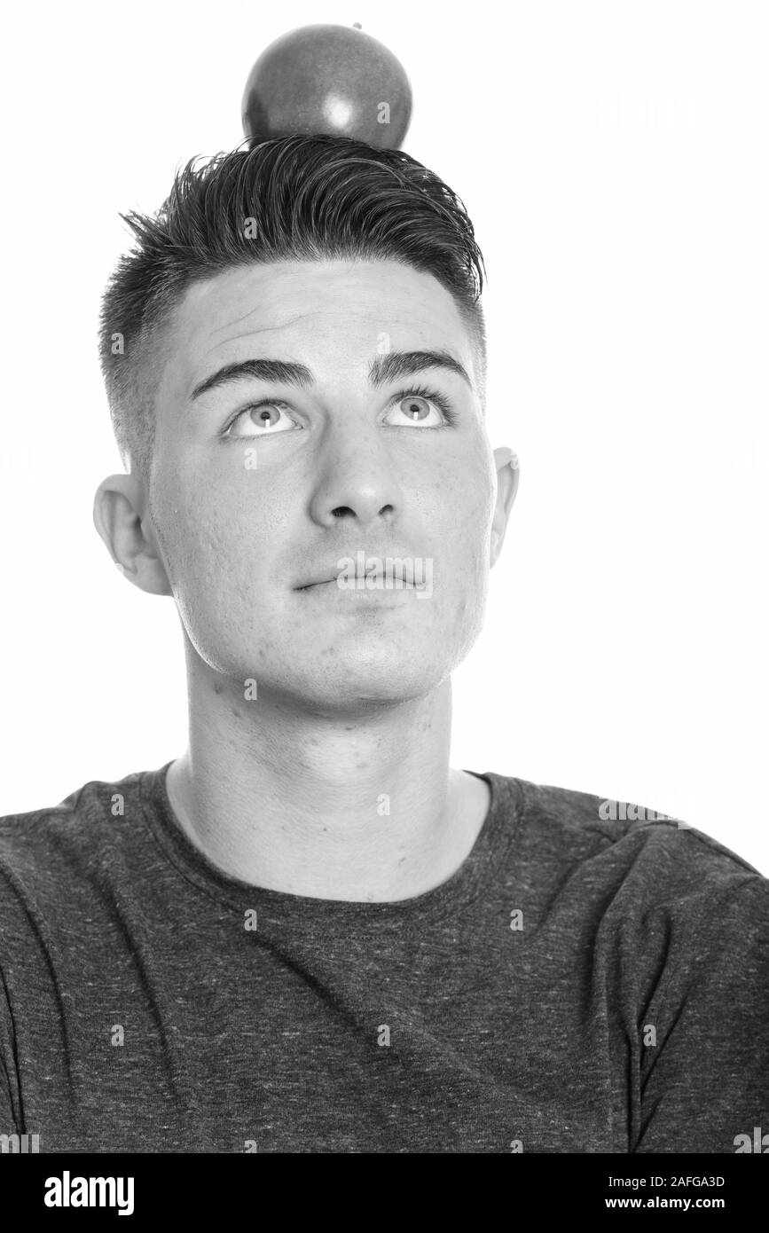 Studio shot of young handsome man with red apple on his head Stock ...
