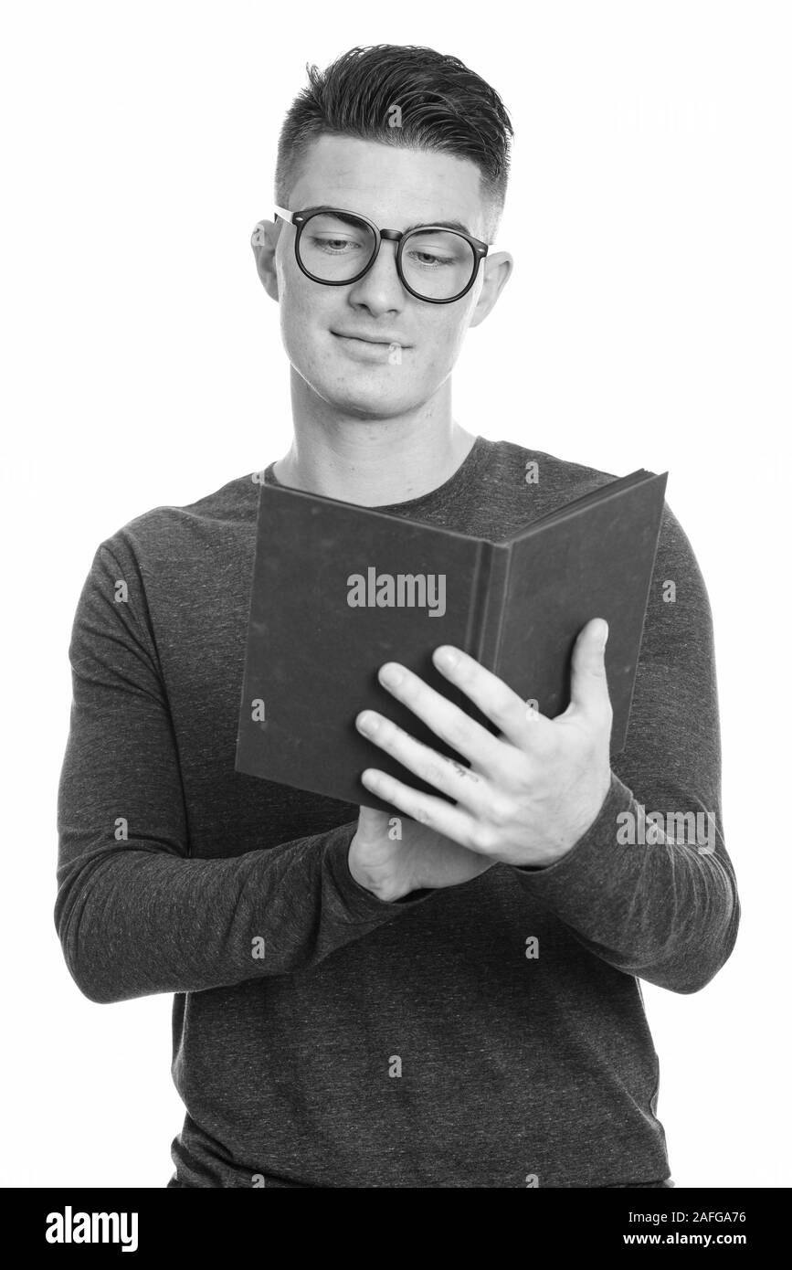 Studio shot of young handsome man reading book Stock Photo - Alamy