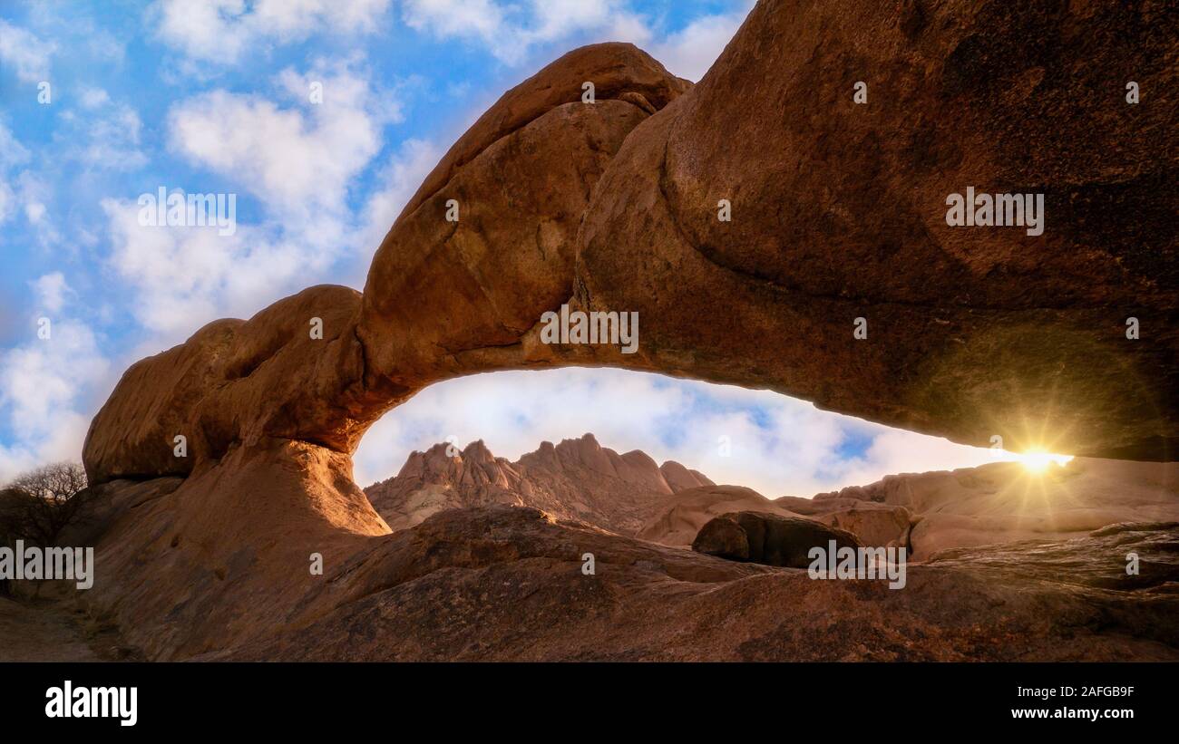 Ancient granite rock forming a natural arch in the Namib Desert, at ...