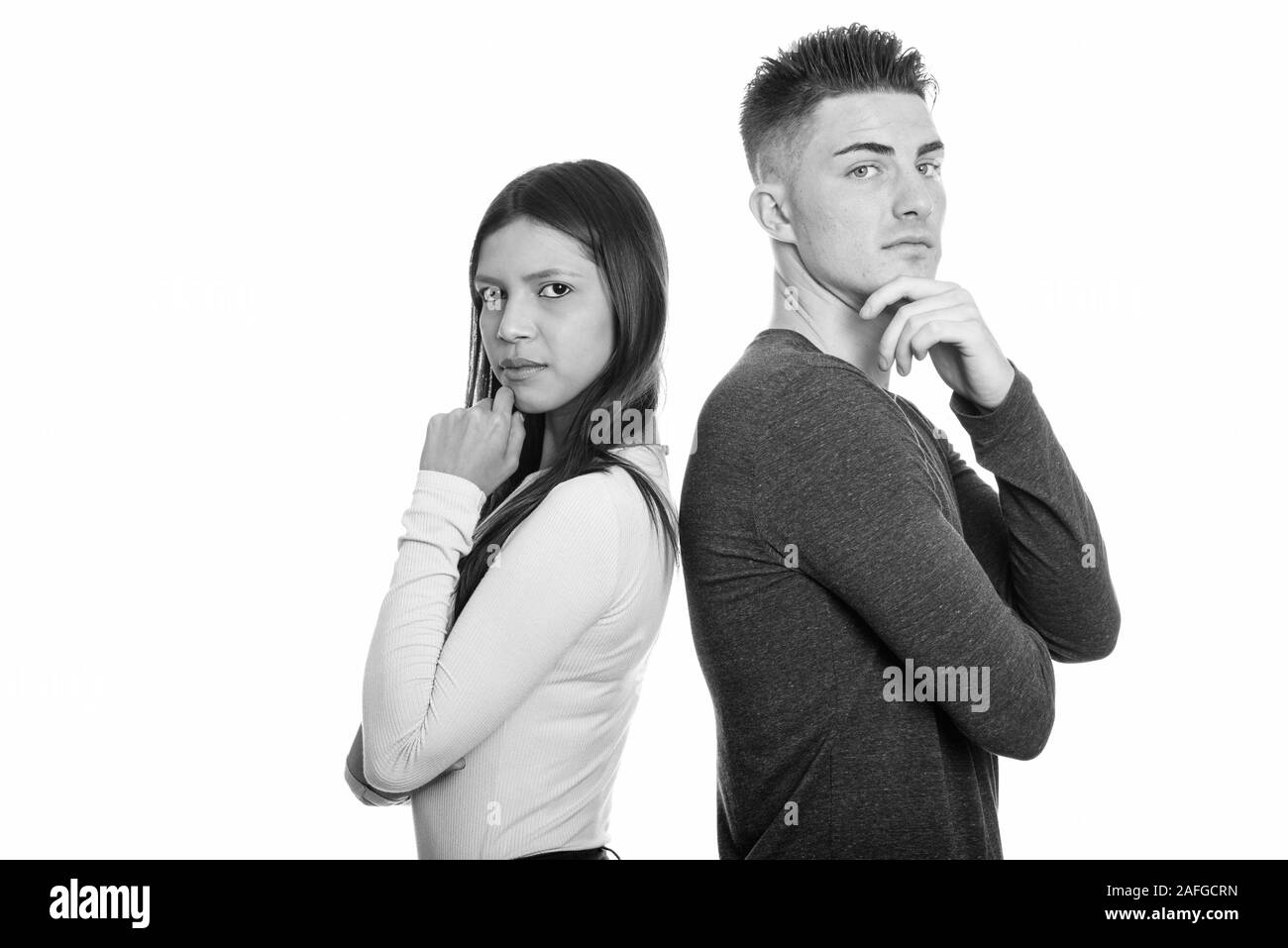 Studio shot of young couple thinking together back to back Stock Photo ...