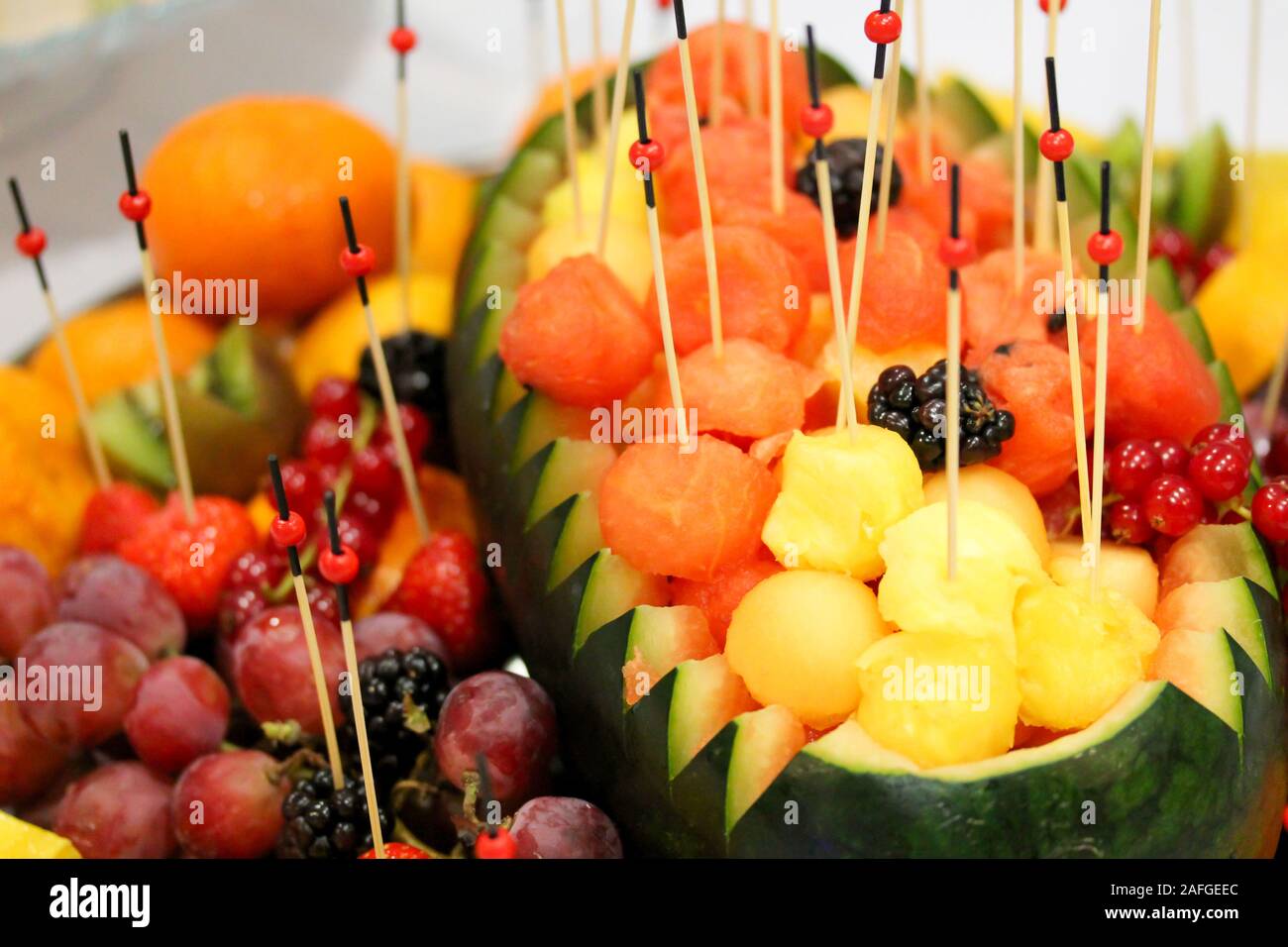 Plate with fruits and berries at the party. Fresh fruit with wooden ...