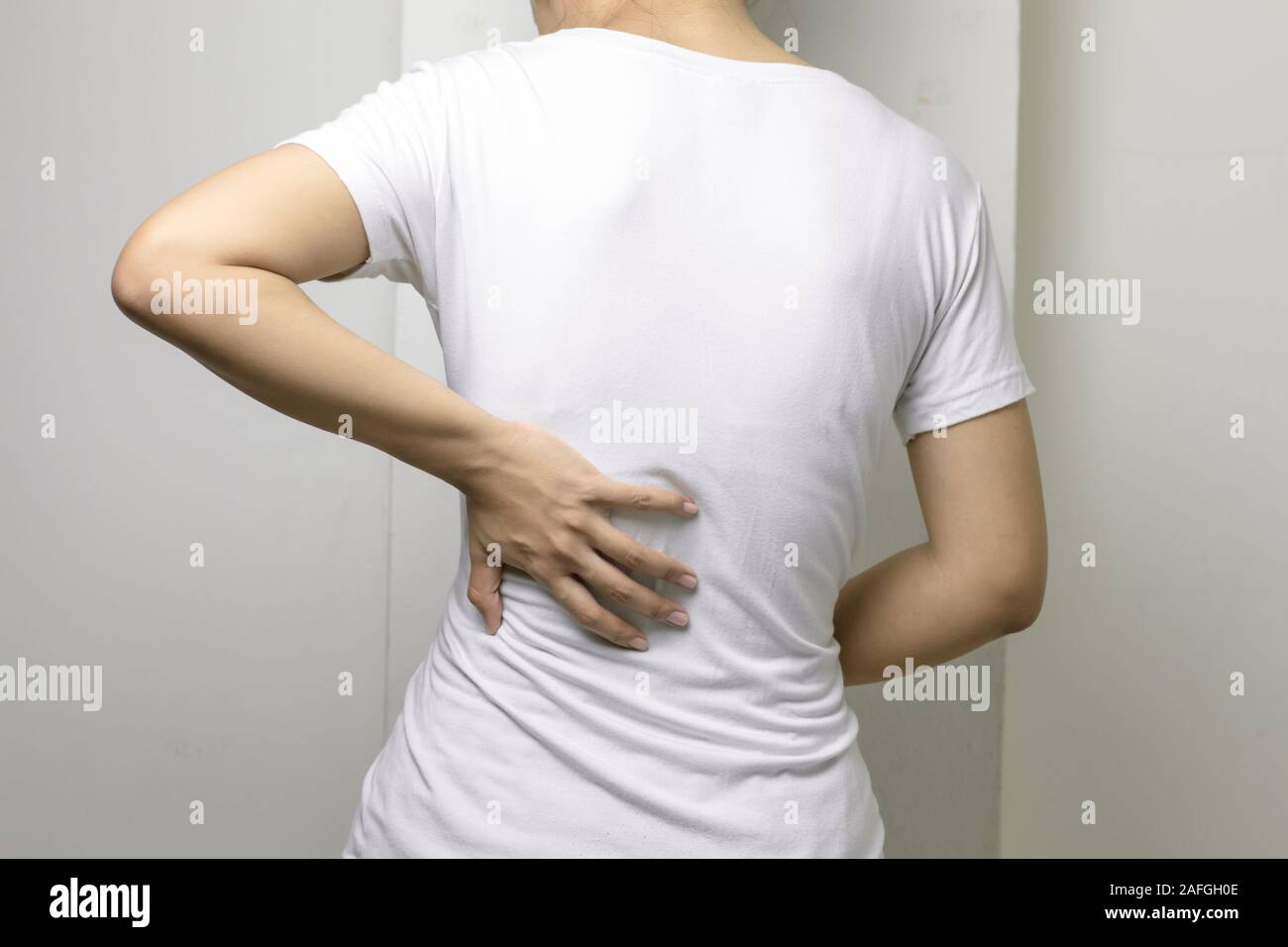 Concept of woman stretching suffering from sudden back pain. Woman ...