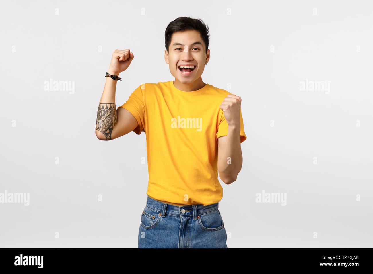 Hooray, well done good for you. Cheerful asian young tattooed man in ...