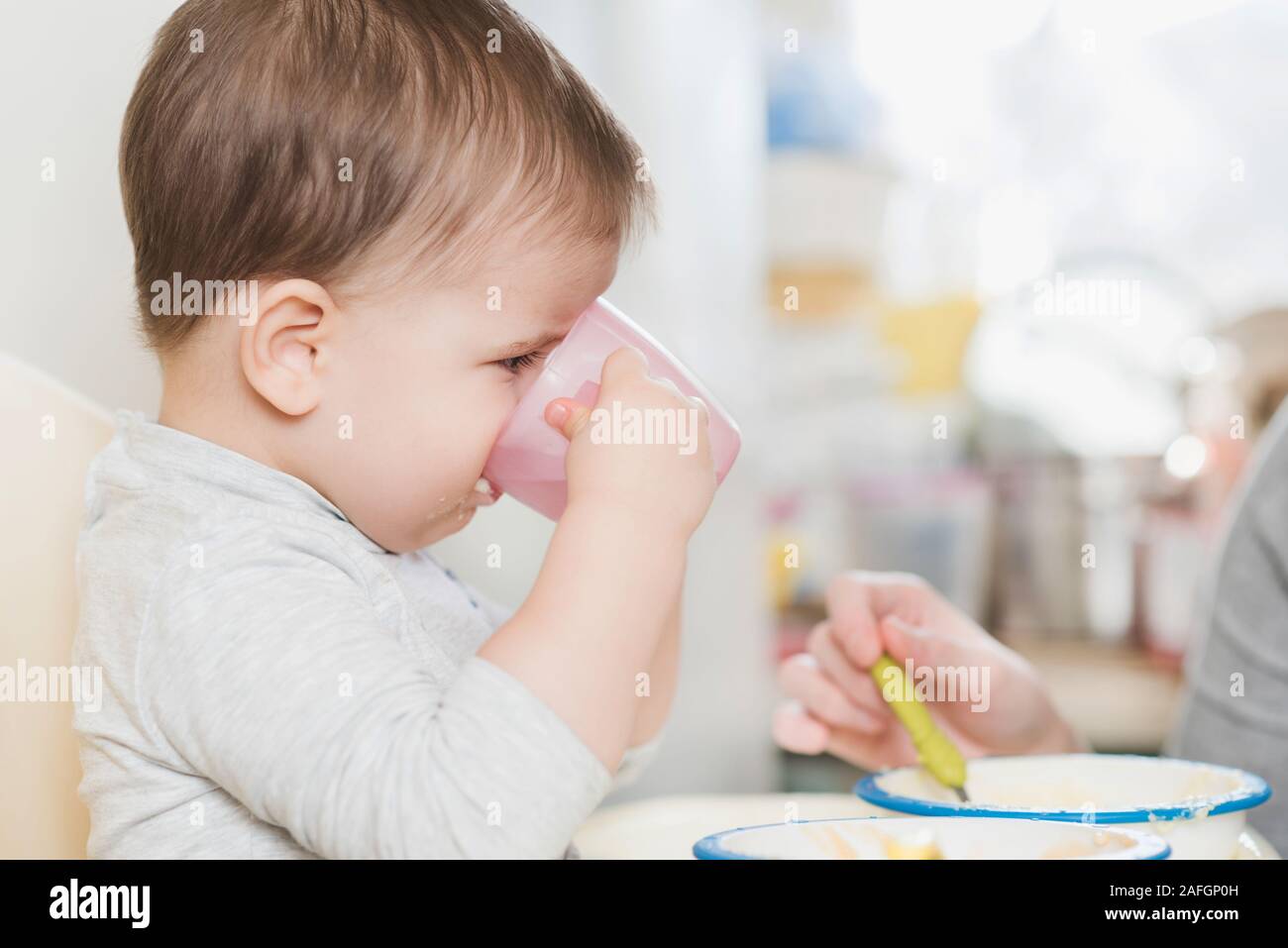 the child in the kitchen drinks water Stock Photo - Alamy