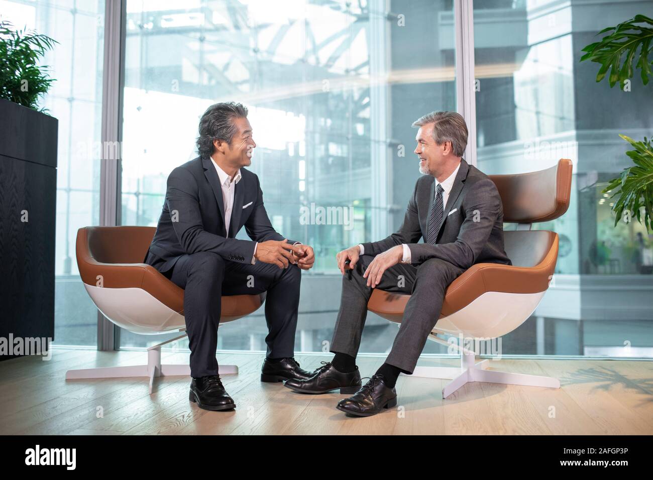 Two businessmen talking in office Stock Photo - Alamy