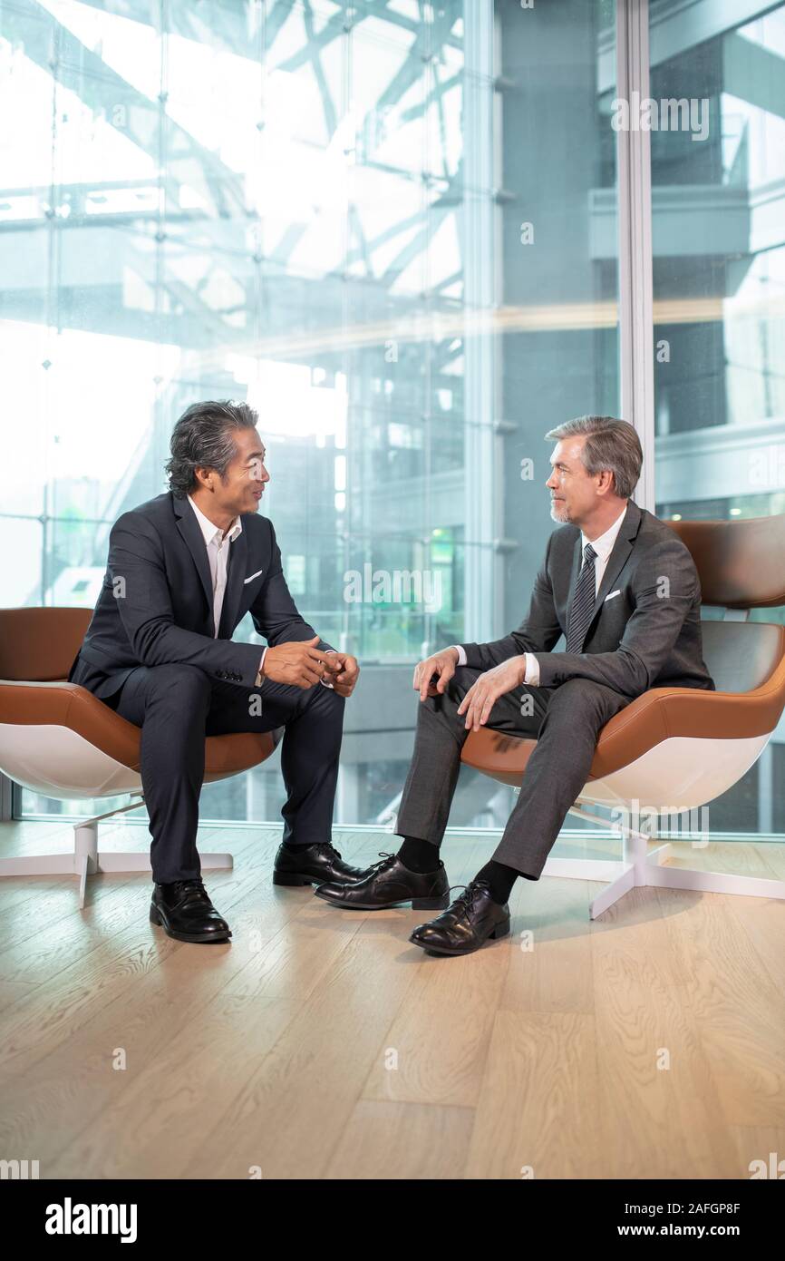 Two businessmen talking in office Stock Photo - Alamy