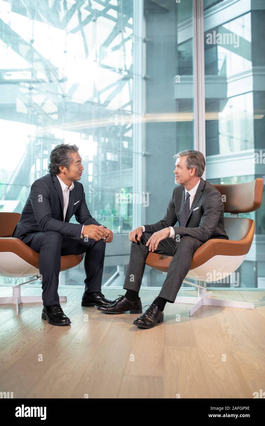Two businessmen talking in office Stock Photo - Alamy