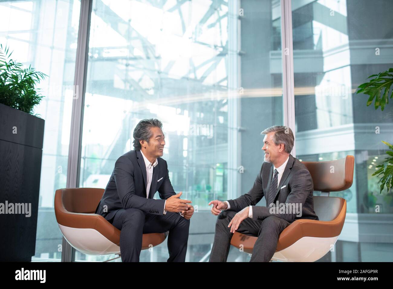 Two businessmen talking in office Stock Photo - Alamy