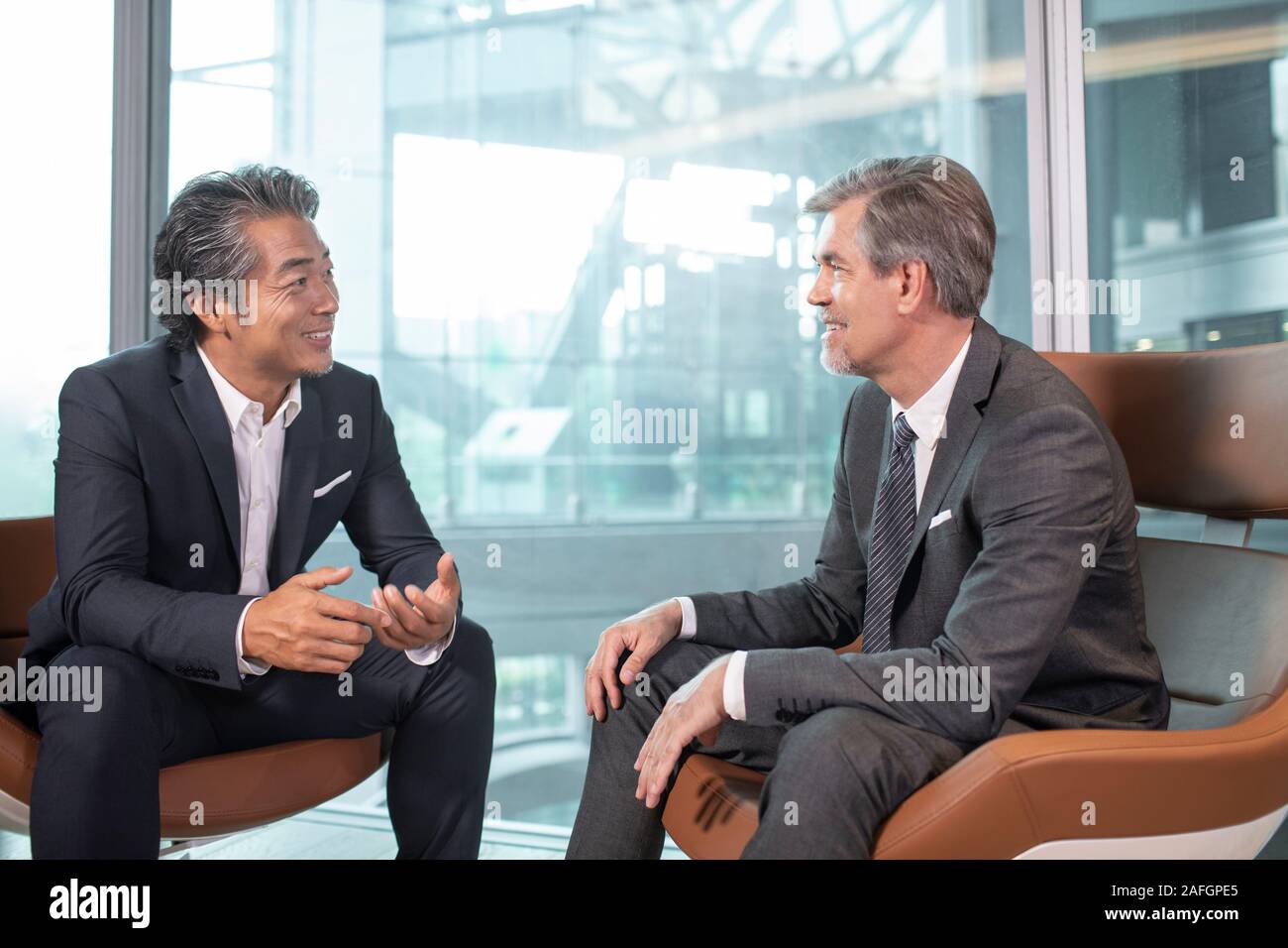 Two businessmen talking in office Stock Photo - Alamy