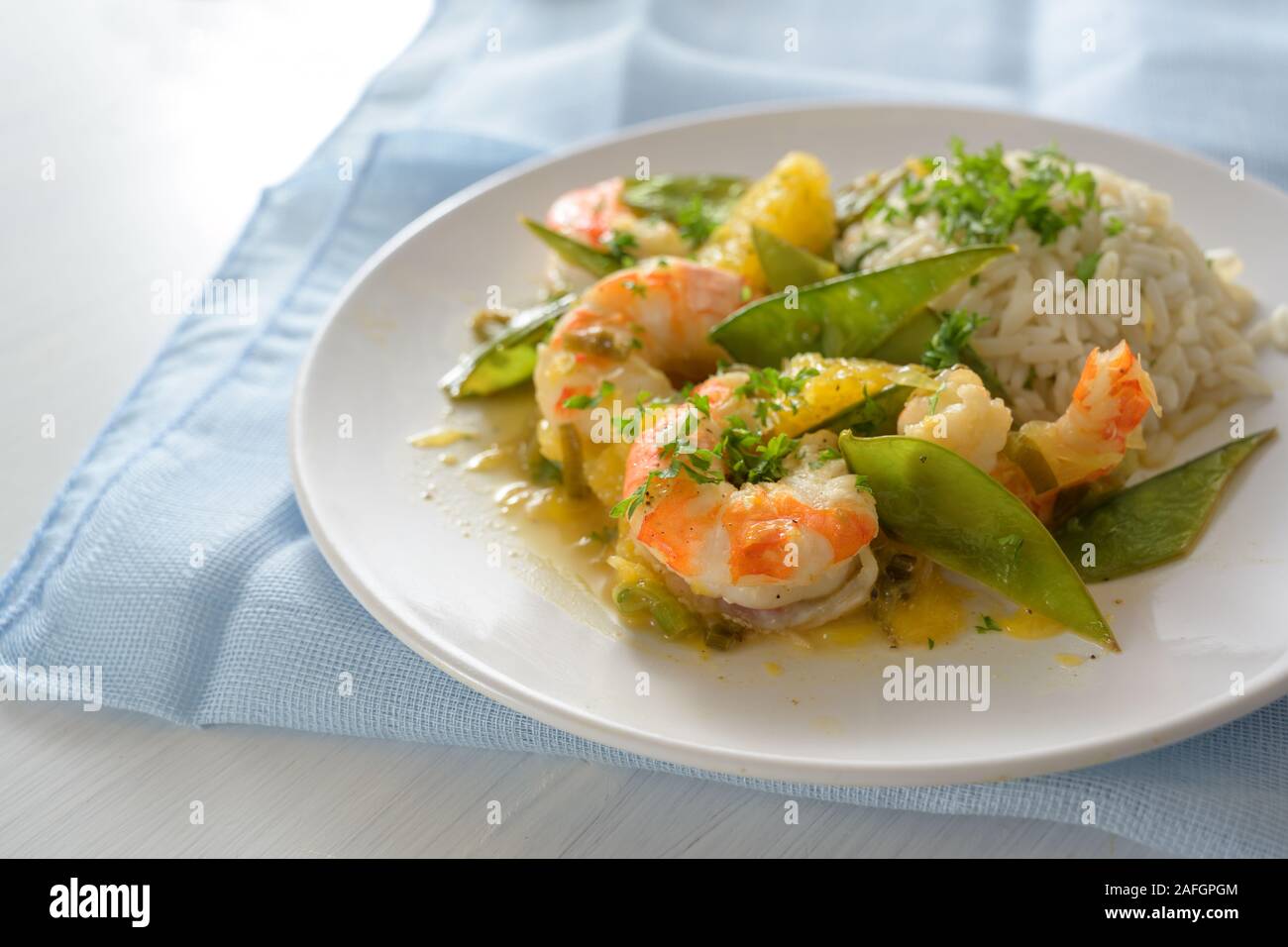 Seafood meal from fried tiger prawn shrimps with sugar peas, oranges ...